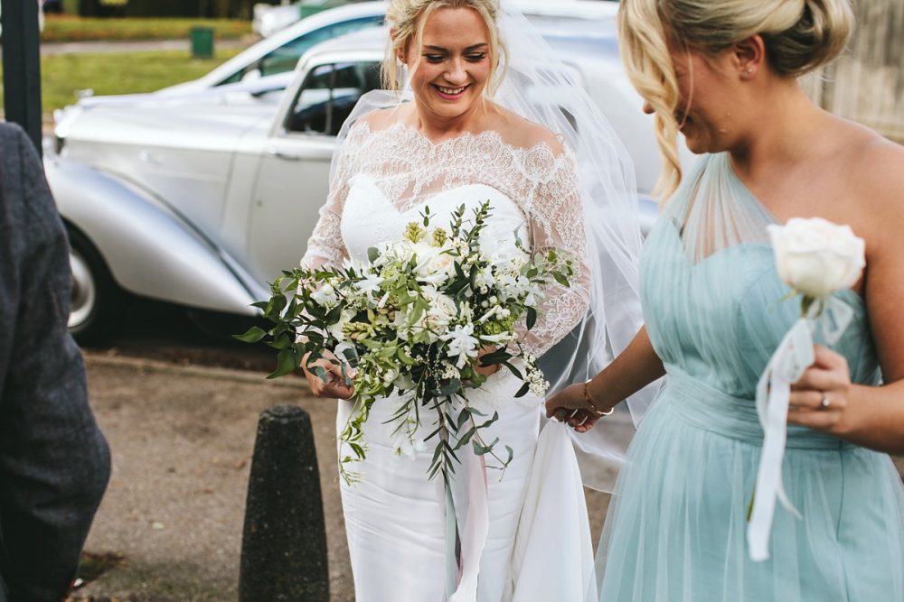 A Suzanne Neville Bride in a Classic, Long-Sleeved Lace Dress for a ...